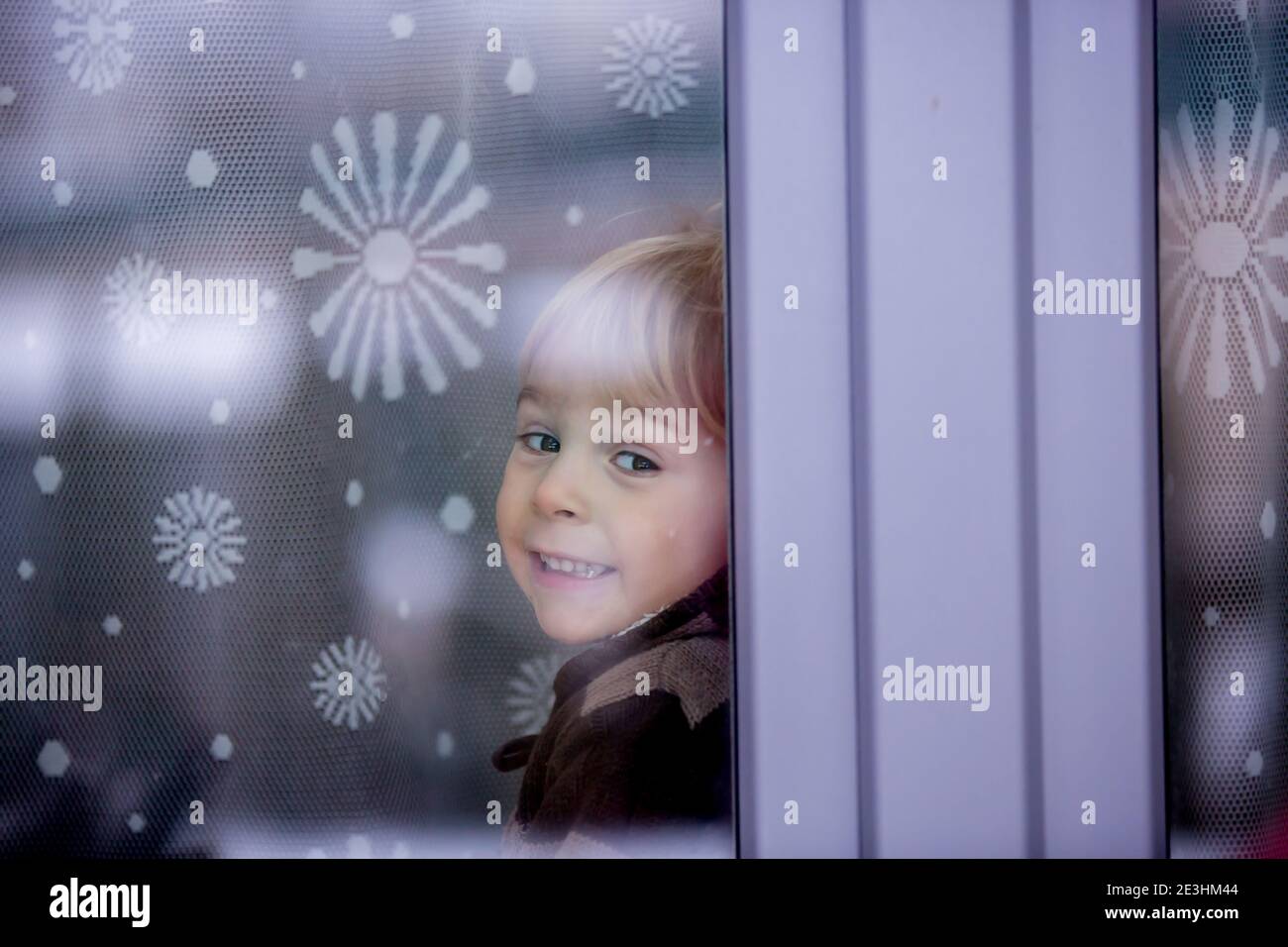 Little toddler boy, sitting behind the window, looking outside Stock ...