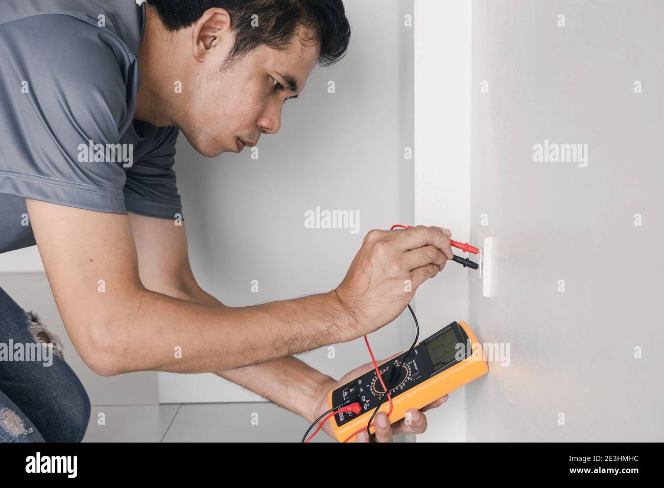 Electrician is using a digital meter to measure the voltage at the ...