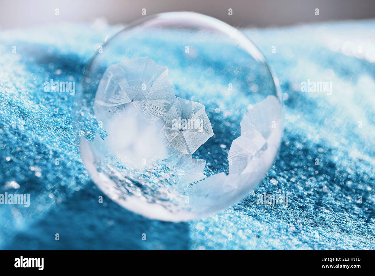 frozen bubble with bokeh background. Beautiful frosty patterns on frozen soap bubble. winter ...