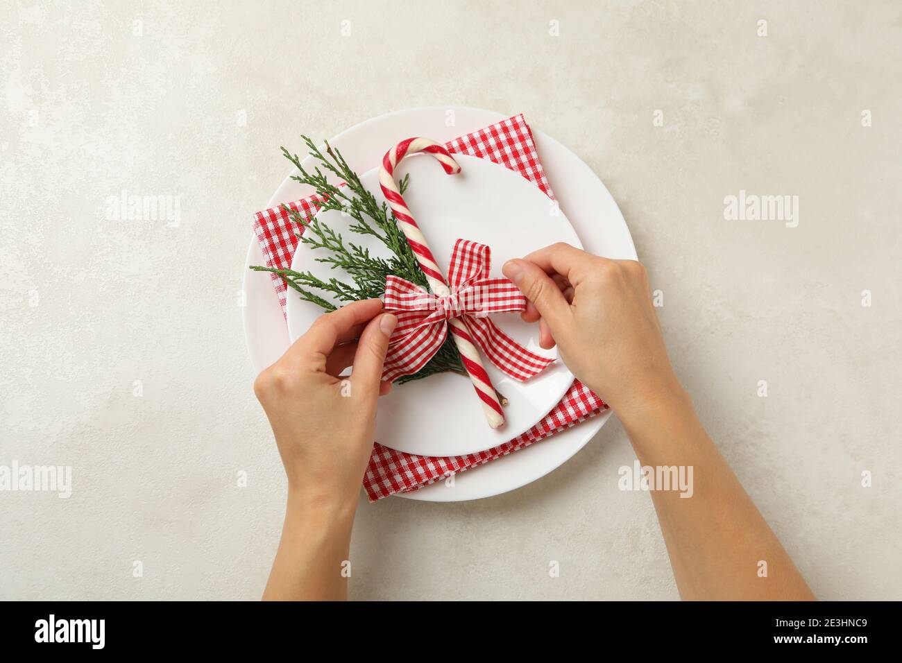 Woman tying a bow on New year table setting, top view Stock Photo - Alamy