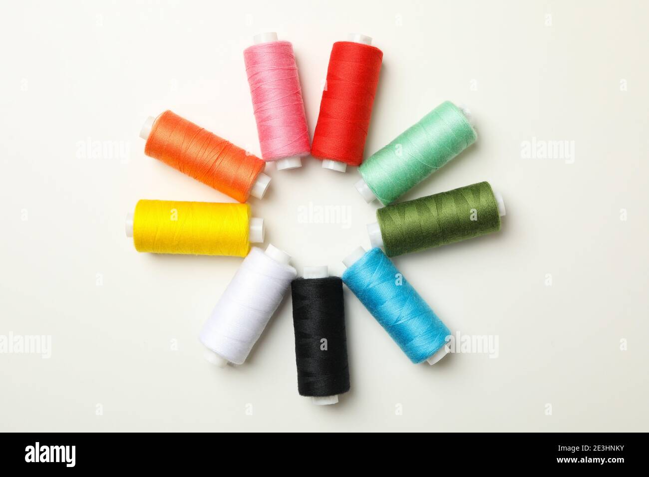 Color sewing threads on white background, top view Stock Photo - Alamy