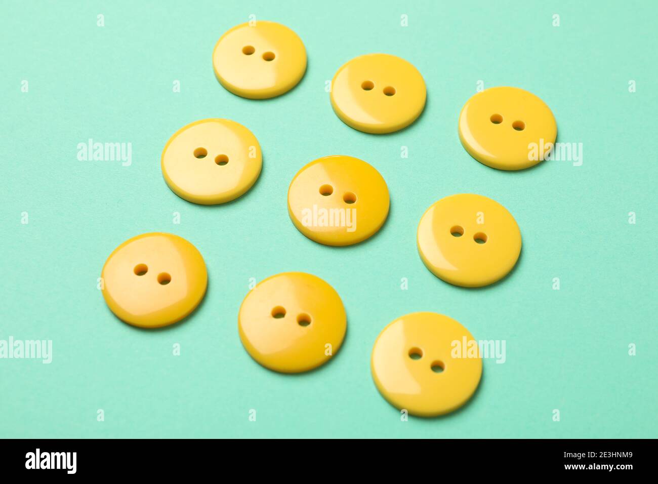 Flat lay with yellow buttons on mint background Stock Photo - Alamy