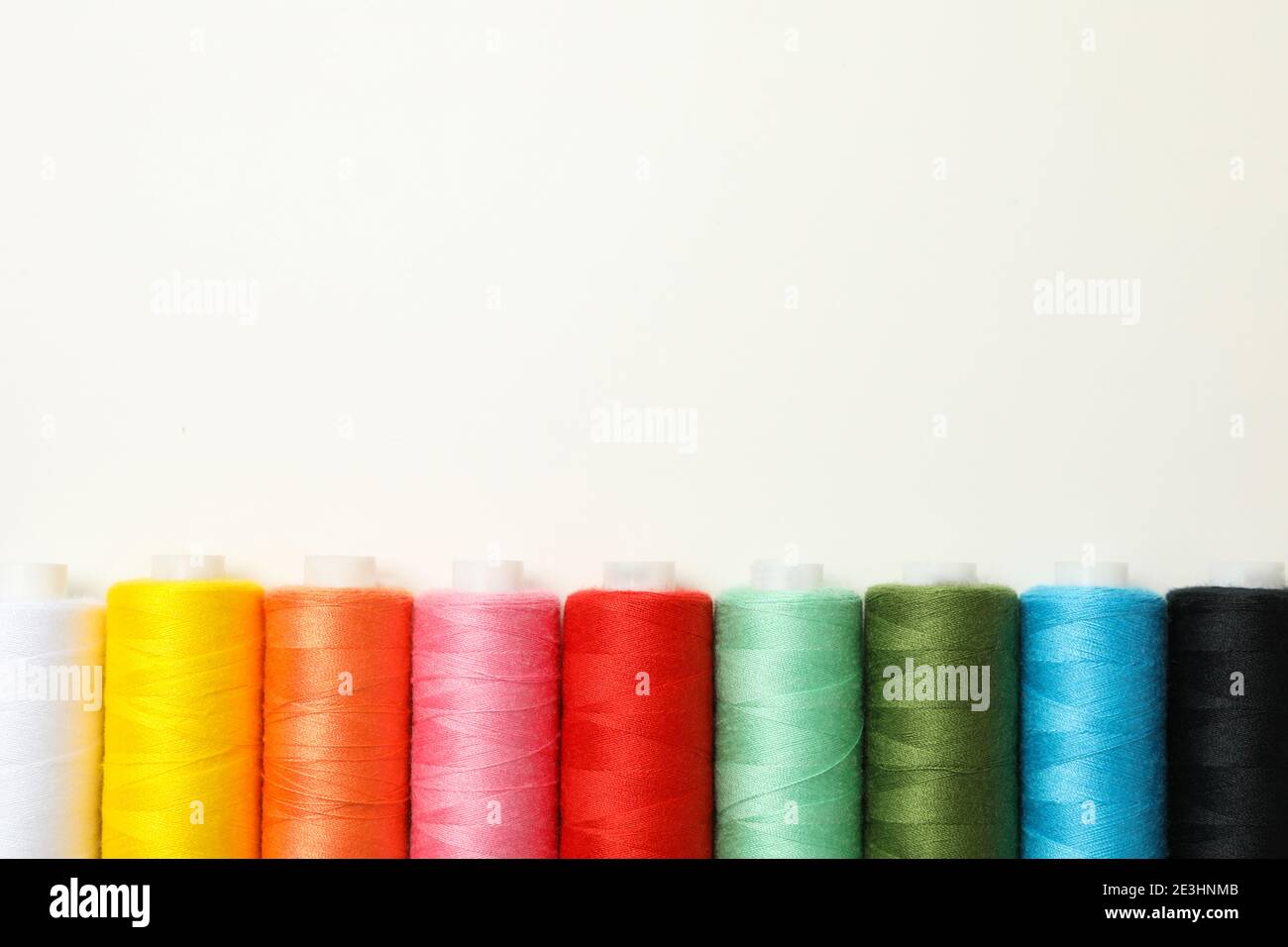 Color sewing threads on white background, space for text Stock Photo ...