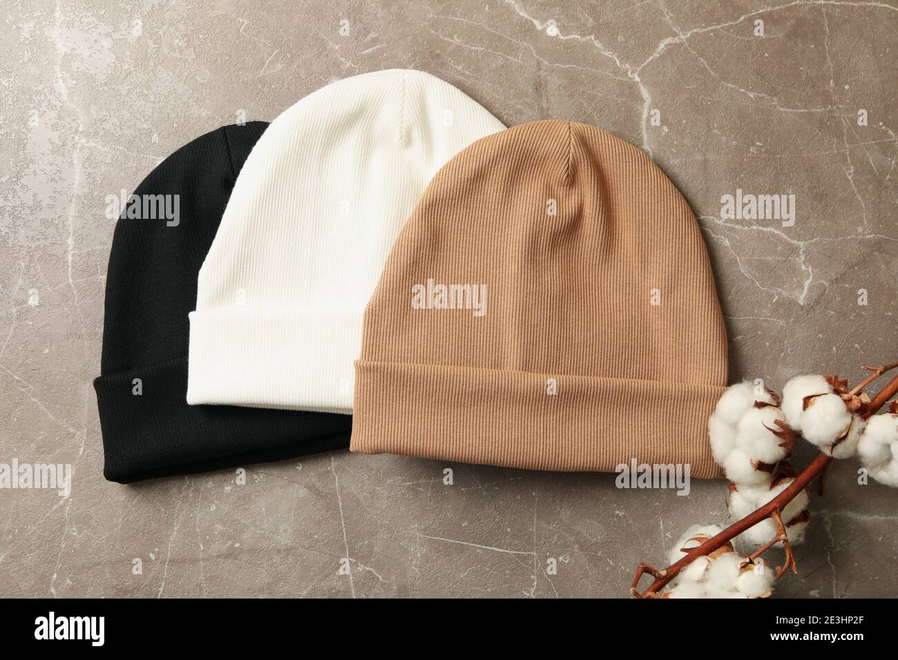 Stylish beanies and cotton on gray background Stock Photo - Alamy