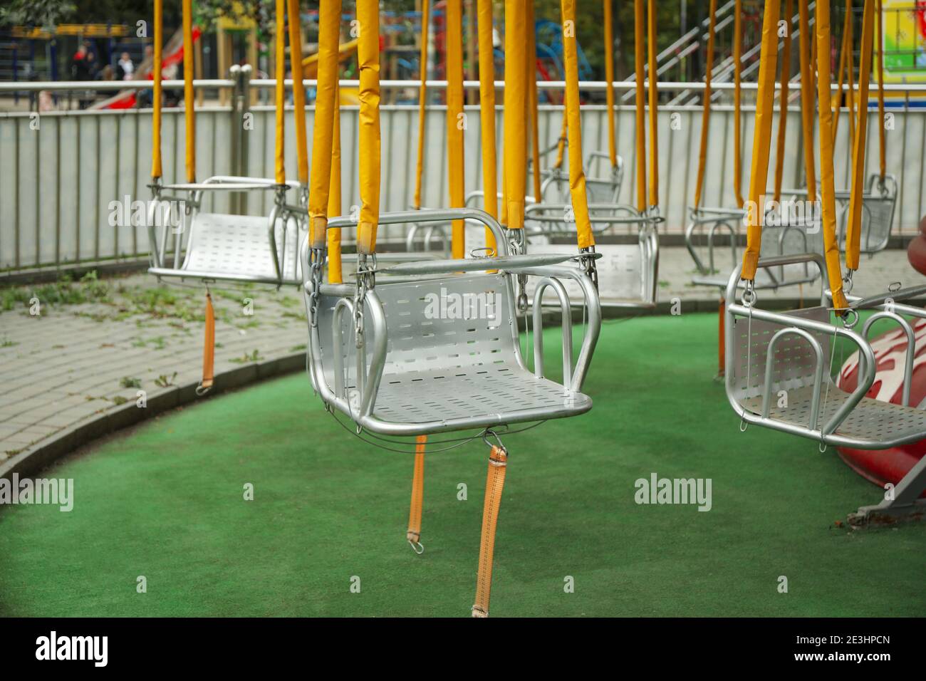 Empty swings of carousel in attraction park Stock Photo - Alamy