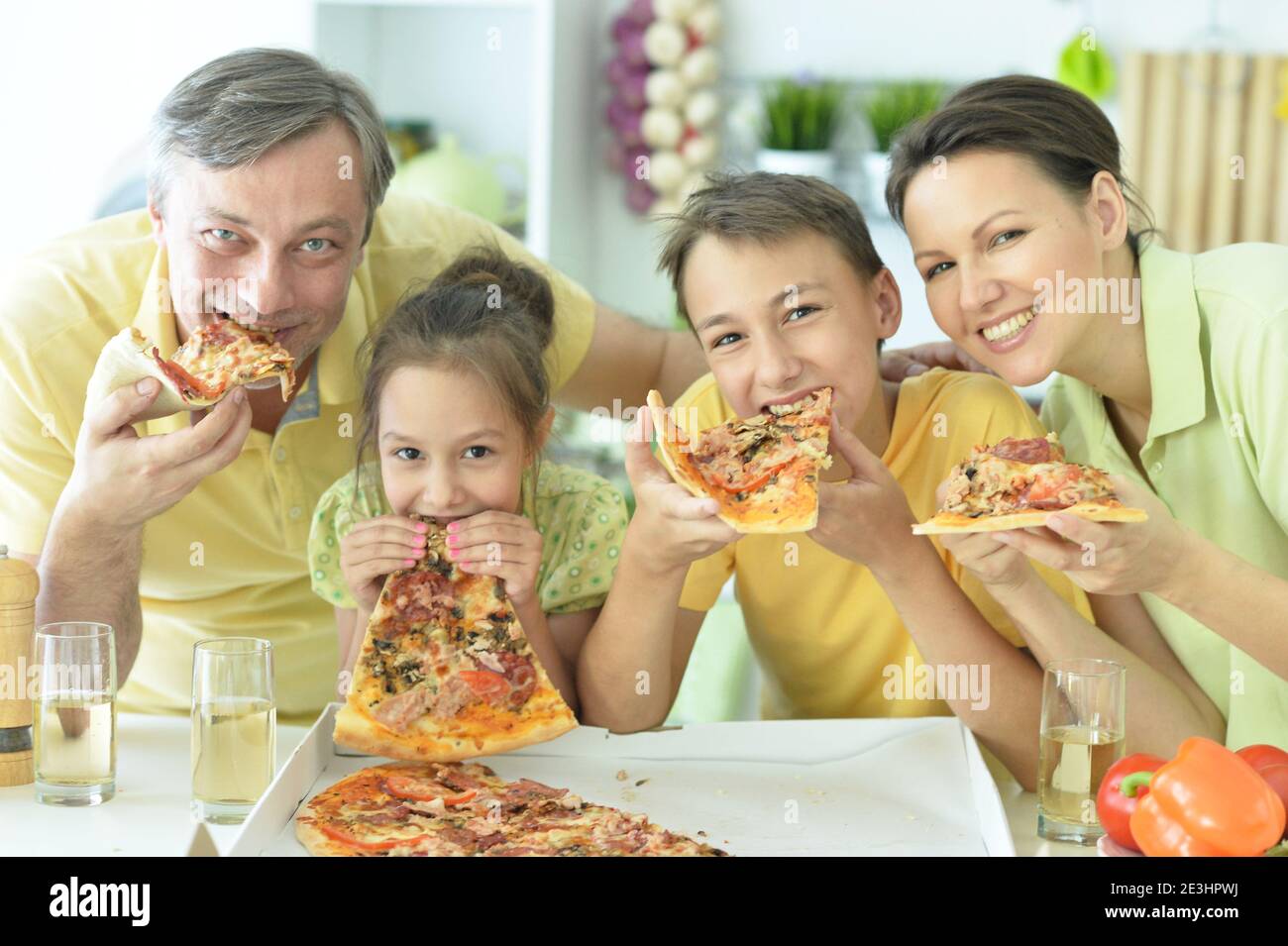Portrait of happy family eating pizza together Stock Photo - Alamy