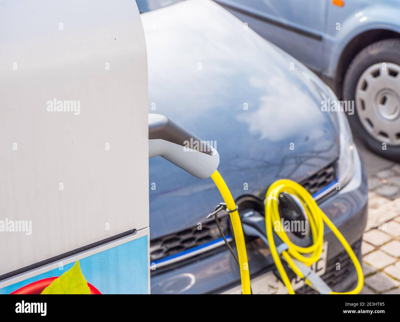 Charging modern electric car with power supply plugged in Stock Photo ...