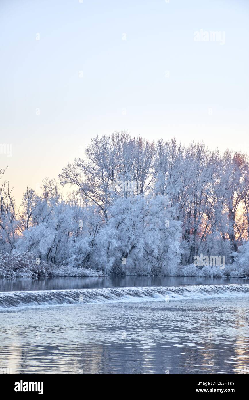 Vertical view of a sunset with the golden hour in winter and the frozen ...