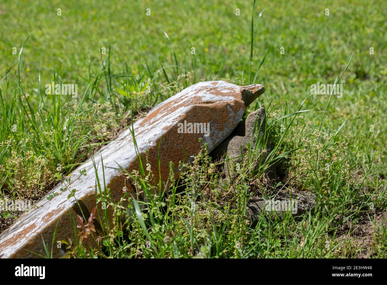 Close up of an old, broken tombstone in a field Stock Photo - Alamy