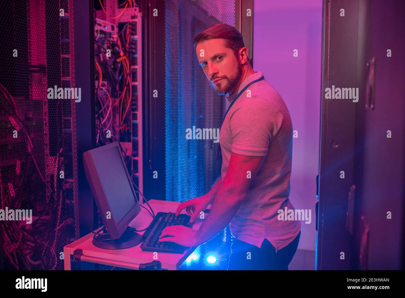 Man in server room working on computer Stock Photo - Alamy
