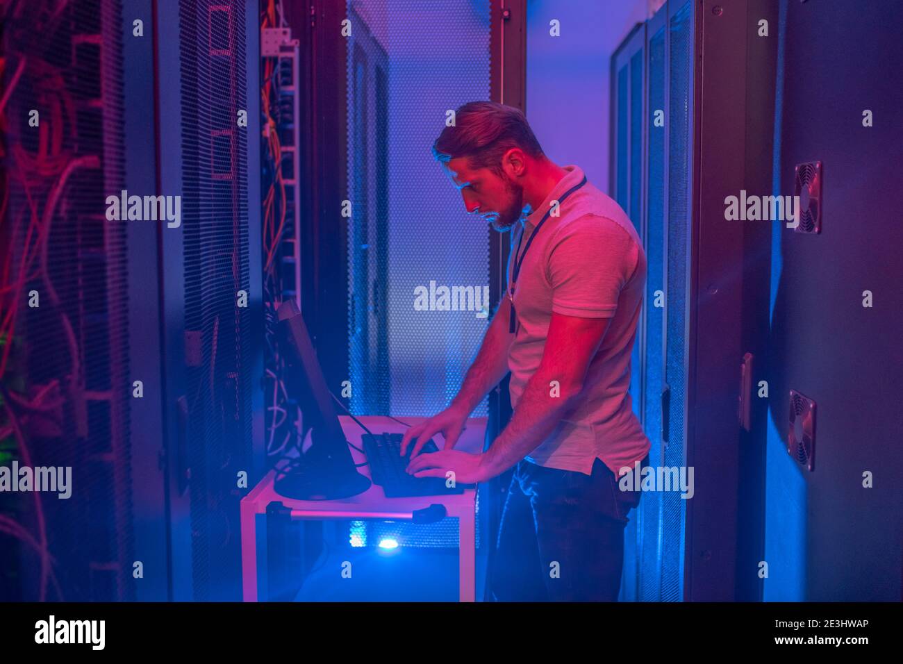 Man in dark server room with blue backlight Stock Photo - Alamy