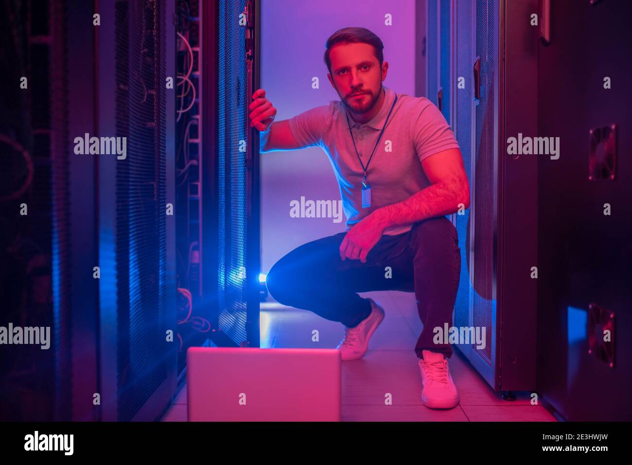 Confident young male administrator near workstation Stock Photo - Alamy