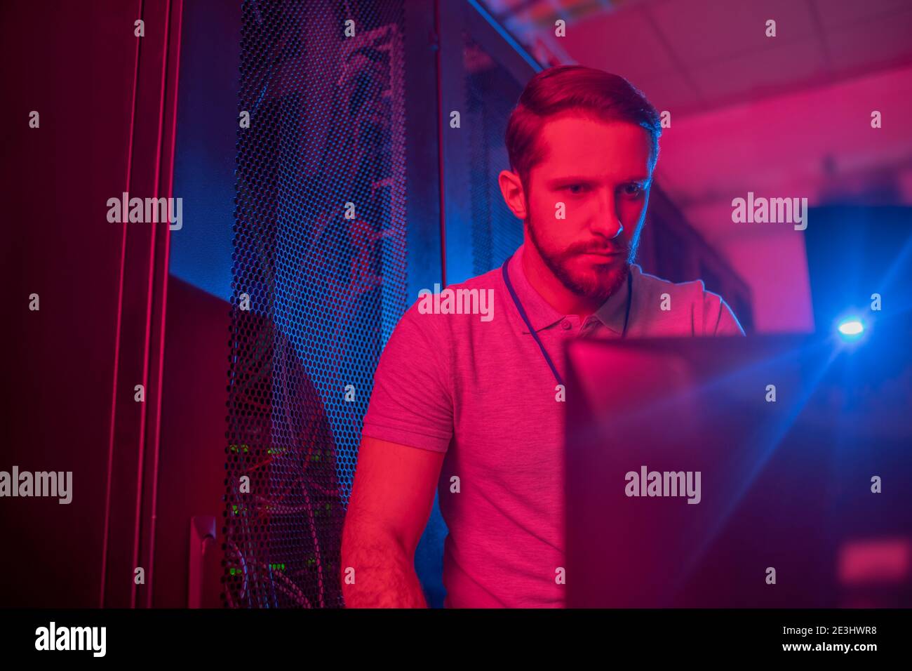 Man near server rack at computer in datacenter Stock Photo - Alamy