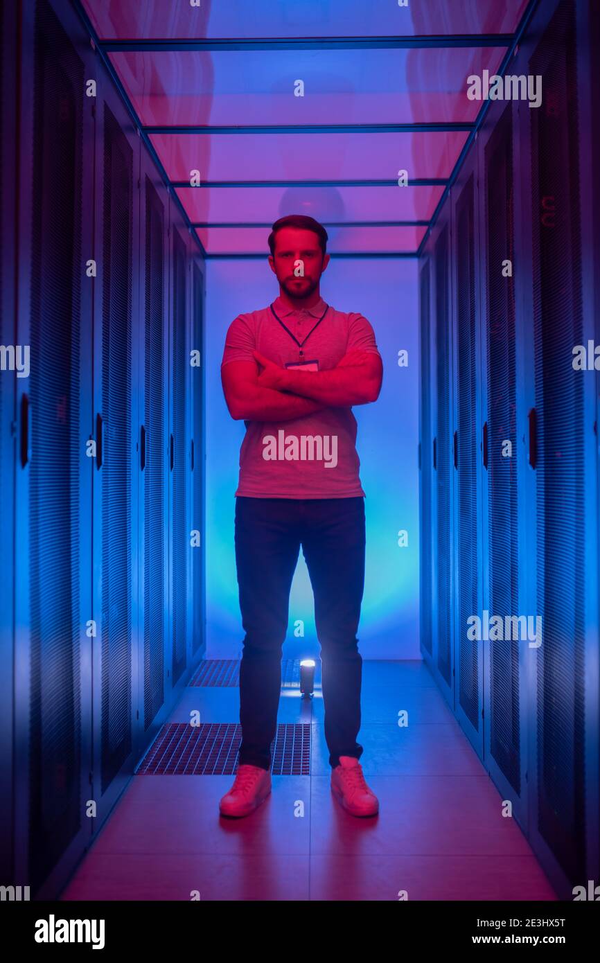 Muscular young man standing near server racks Stock Photo - Alamy
