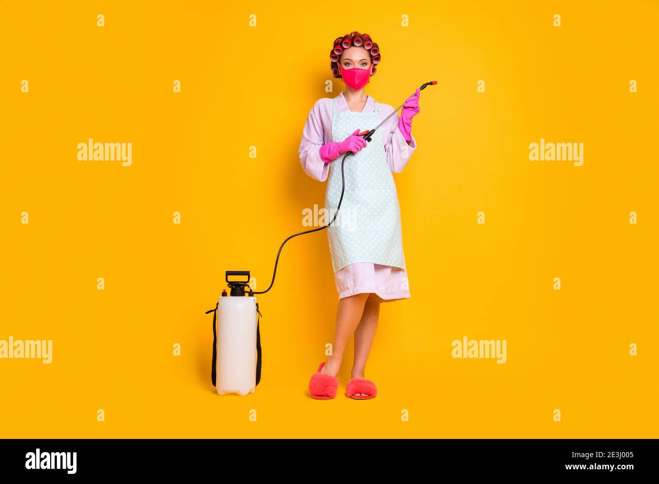 Full length body size view of maid wearing safety mask using tool ...
