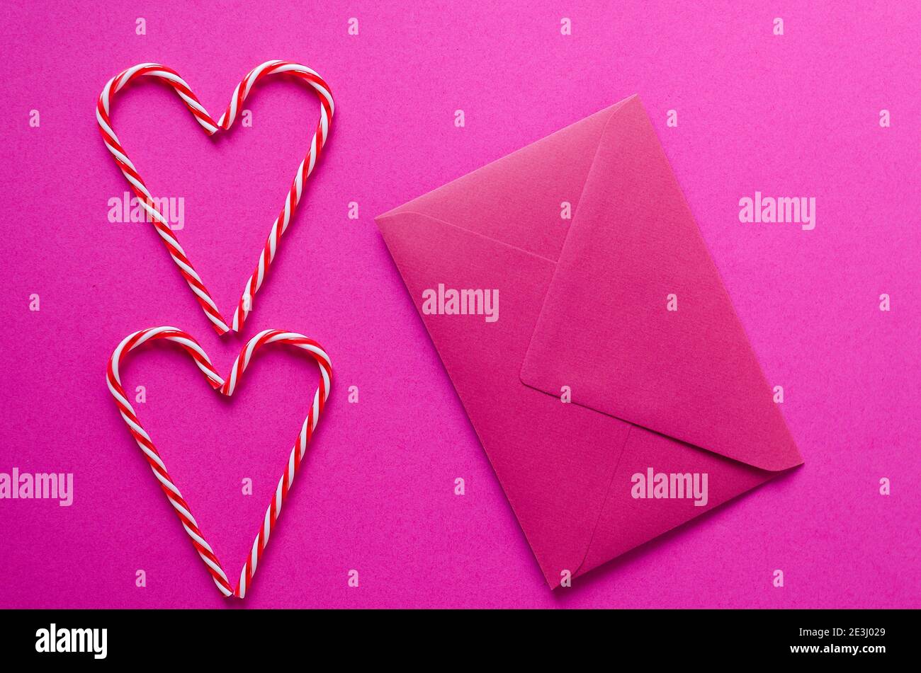 Festive pink background. Hearts of sweet candies with envelope. Love ...
