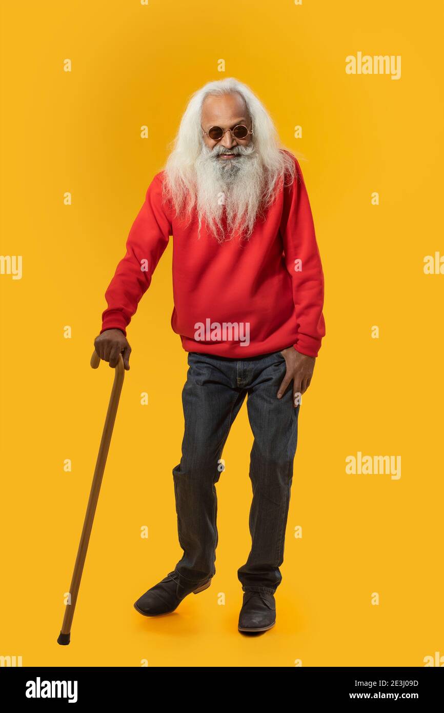 A HAPPY OLD MAN WEARING GOGGLES STANDING AND HOLDING WALKING STICK ...