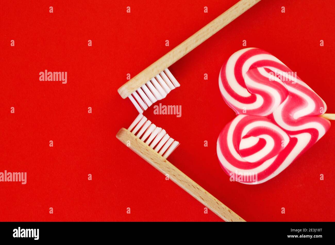 Festive red background. Sweet heart shaped candy. And two toothbrushes ...