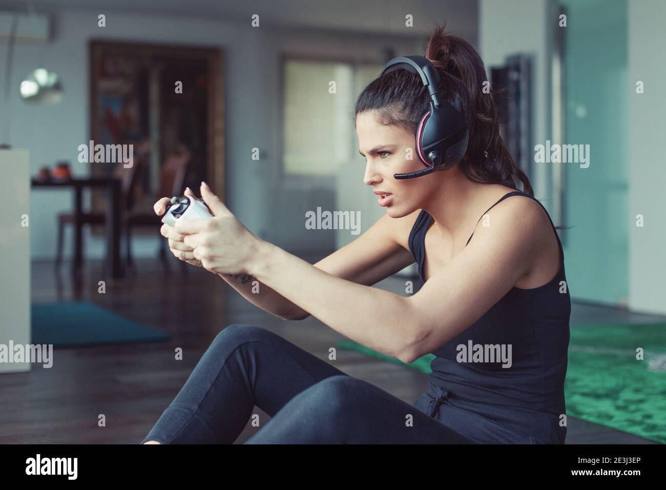 Young Caucasian gamer woman focusing on game while playing indoors ...