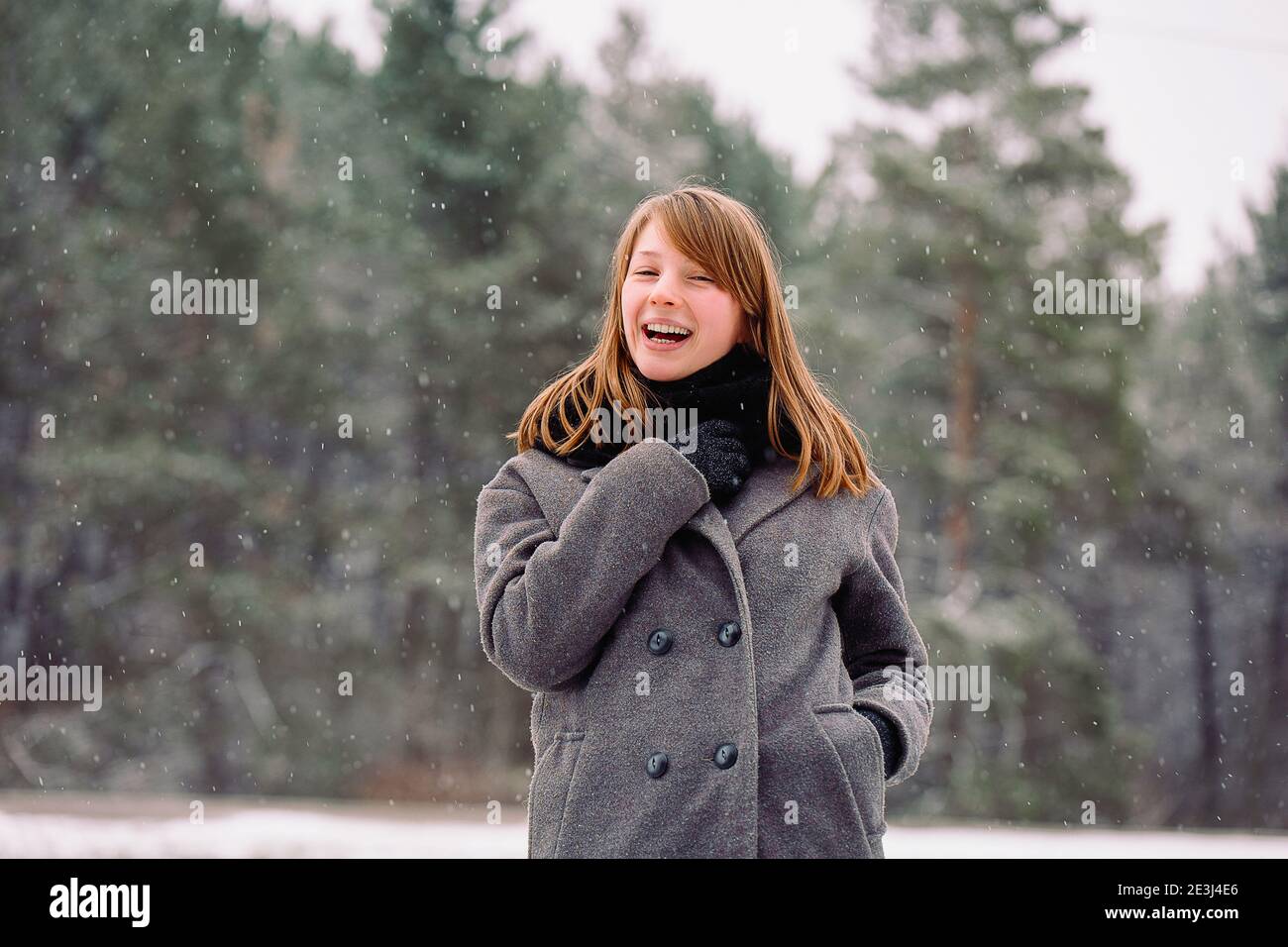 Happy emotions of a young laughing girl in gloves and a warm scarf in ...
