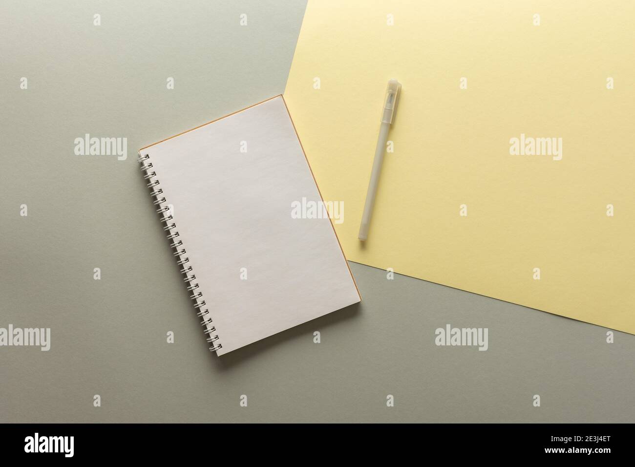 Open spiral notepad on gray and yellow background , notebook and pen ...