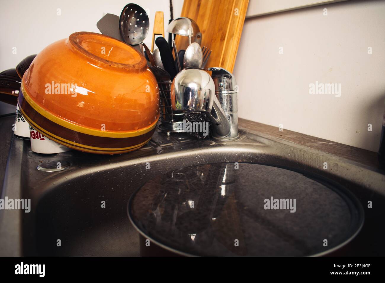 washed dishes with a dirty pot Stock Photo - Alamy