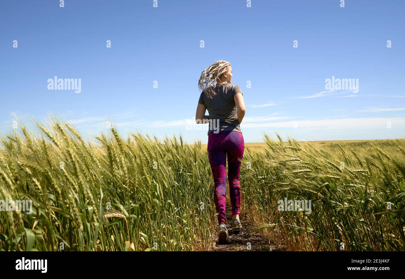 Running In The Wheat Young teen girl running through wheat field in ...