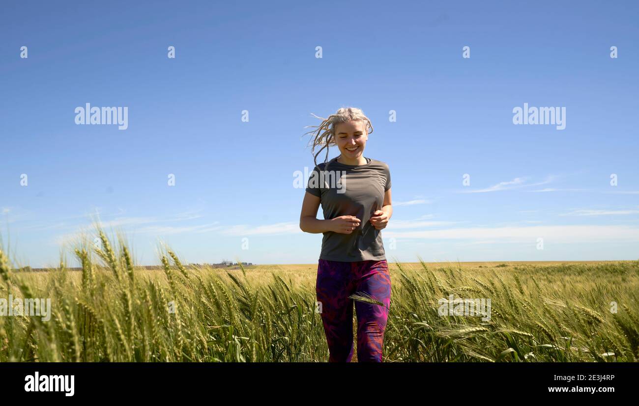 Running In The Wheat Young teen girl running through wheat field in ...
