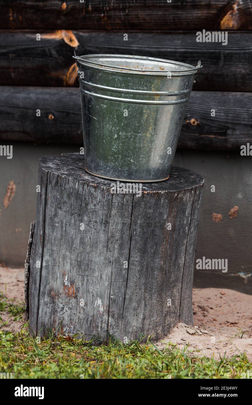 metal water bucket on stumped wood with beatiful background Stock Photo ...