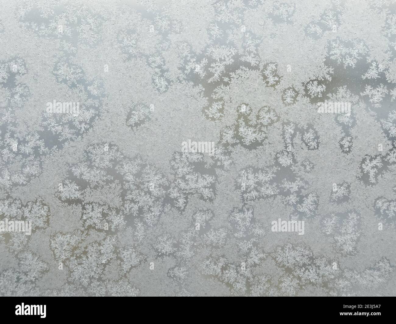 Natural background with white melting frost on the frozen window glass ...