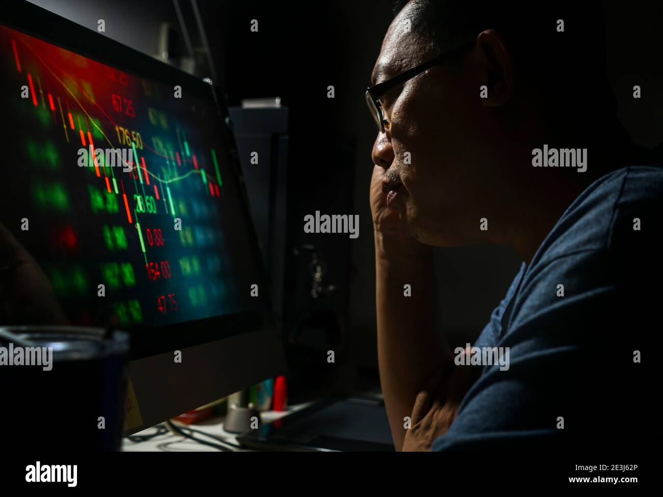 Close up Asian middle-aged man analyzing the candlestick graph chart of ...