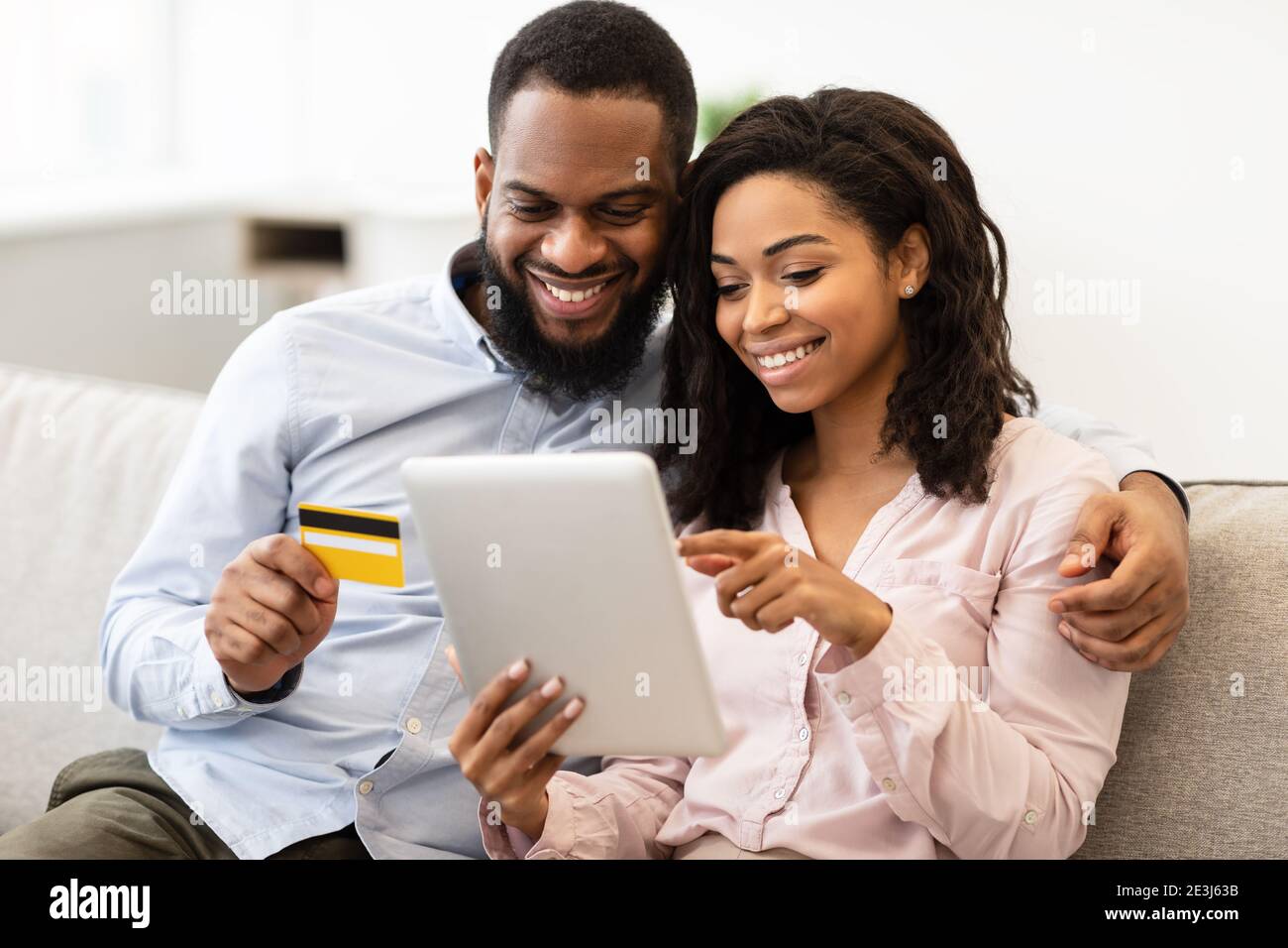 Black couple using tablet and debit credit card at home Stock Photo - Alamy