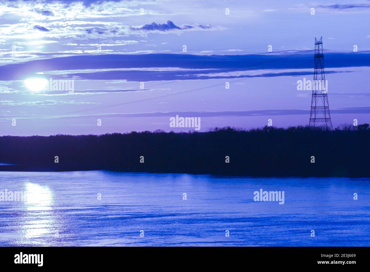 Sunset in a blue, cloudy sky, over water Stock Photo - Alamy