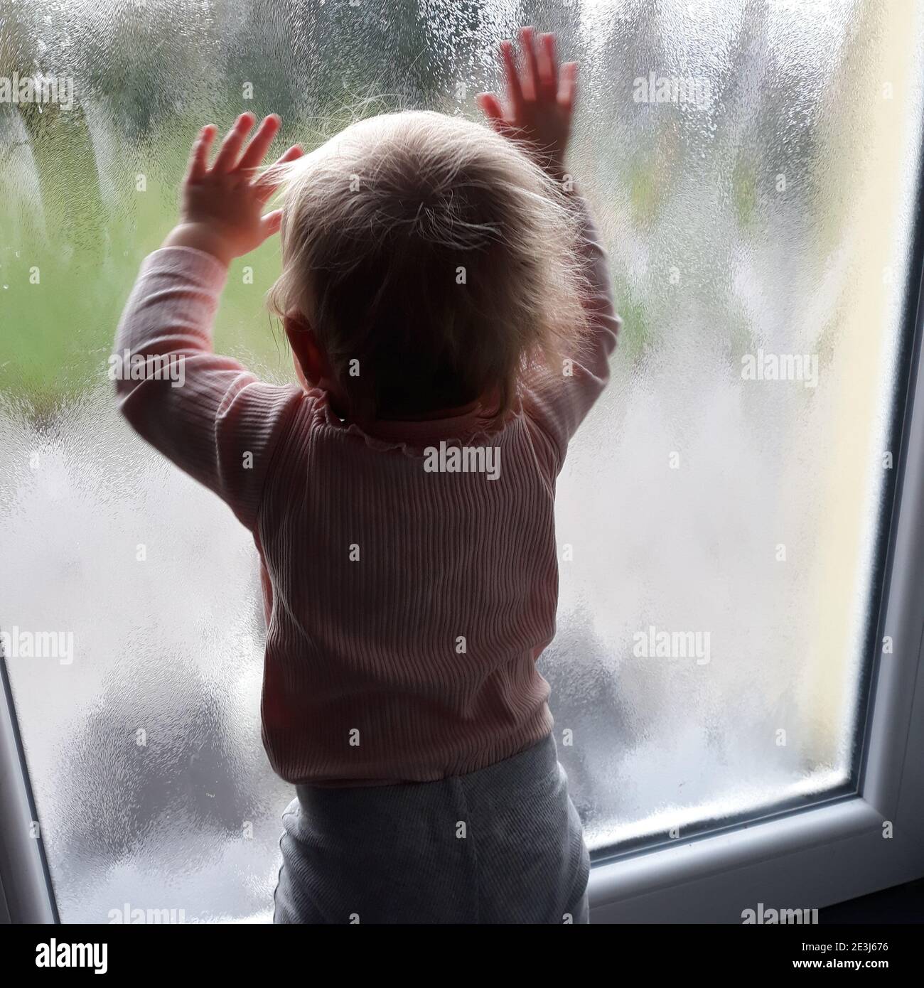 Baby looking out of the window Stock Photo - Alamy