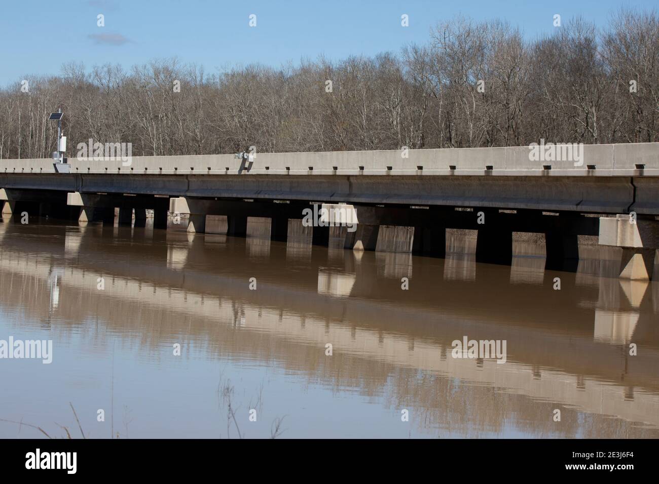 Bridge constructed of concrete running through swamp water in front of ...