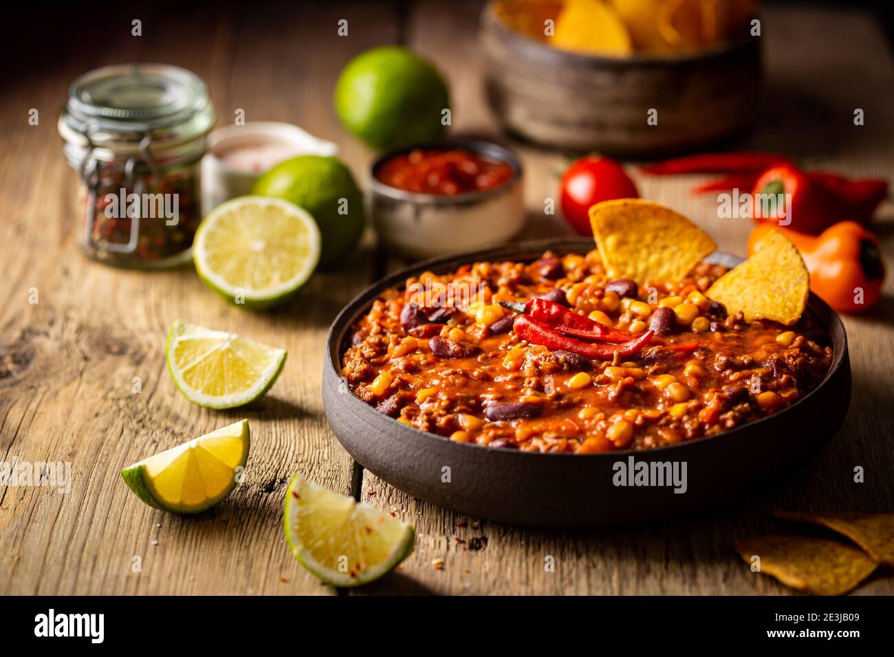 Mexican hot chili con carne in a bowl with tortilla chips on wooden ...