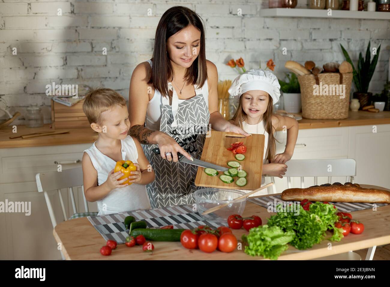Mom cooks lunch with the kids. A woman teaches her daughter to cook ...