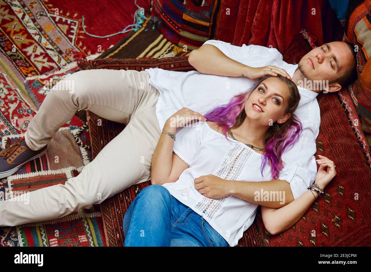 Couple in love chooses a Turkish carpet at the market. Cheerful joyful ...