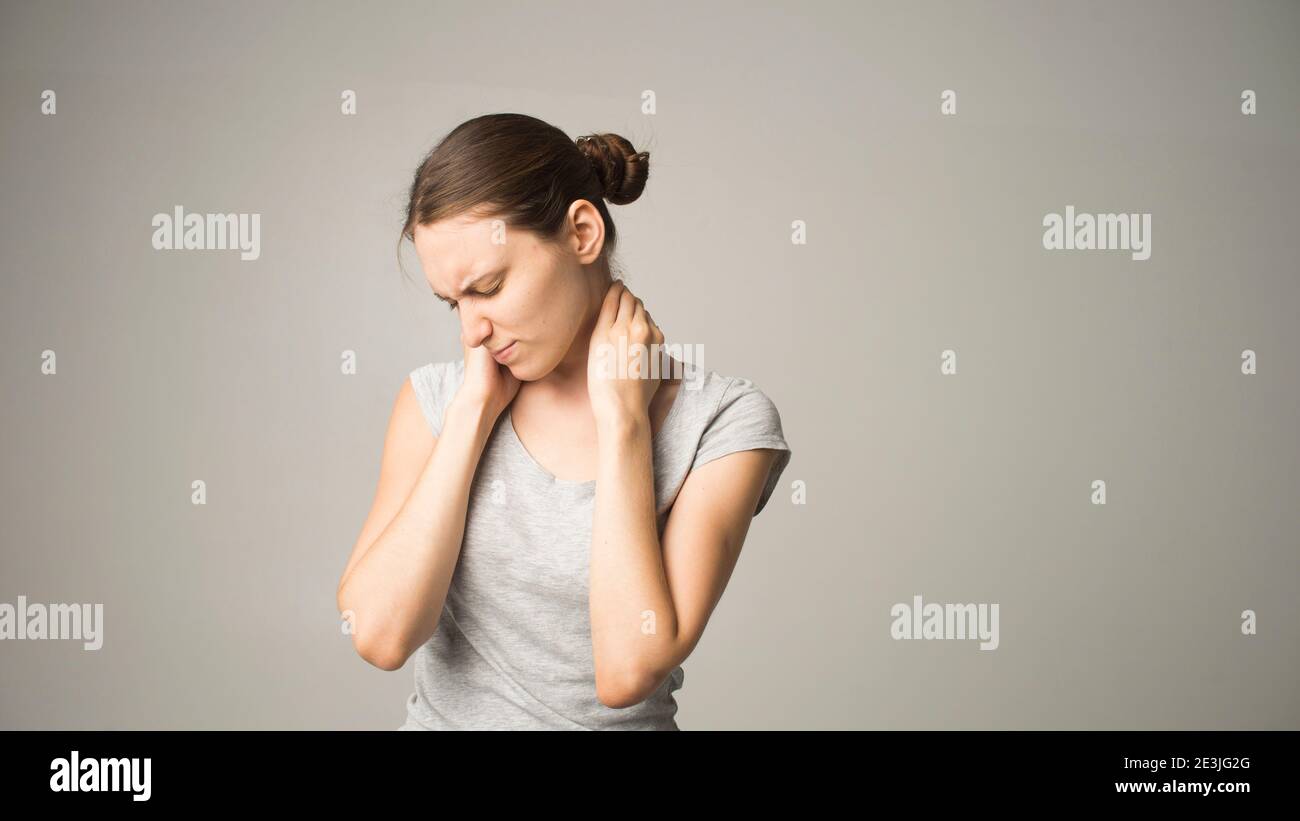 Tired woman feeling pain, massaging tense muscles Stock Photo - Alamy