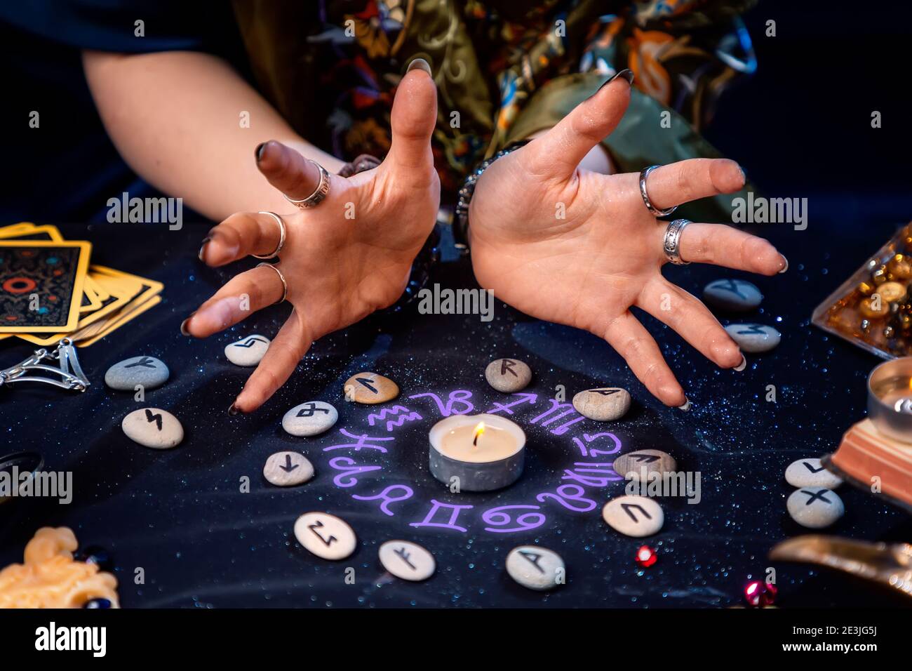 A fortune teller conjures a candle surrounded by runes and the glow of ...