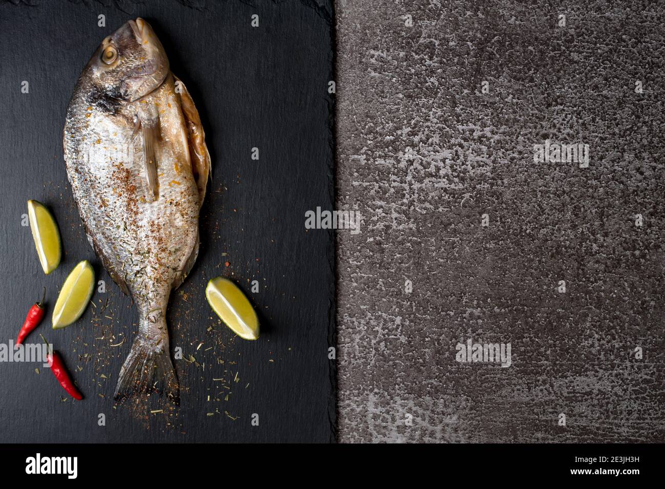 Sea bream on slate board with rosemary hi-res stock photography and ...
