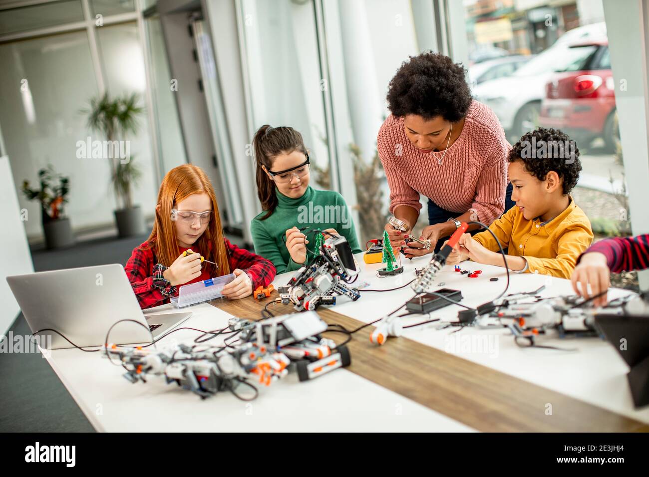 Group of happy kids with their African American female science teacher ...