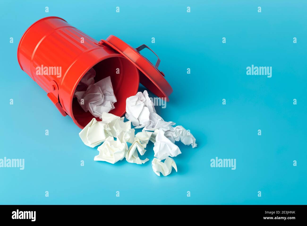 Paper trash and waste in a trash bin on a blue background. Waste and ...