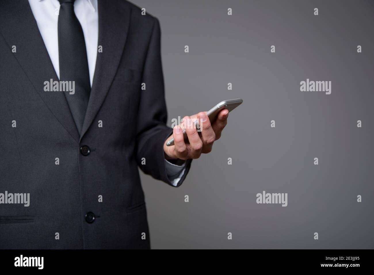 businessman wearing black suit using mobile phone Stock Photo - Alamy