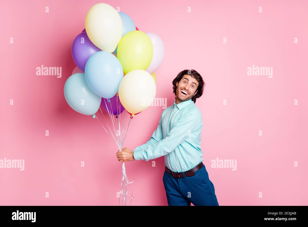 Photo portrait of glad guy holding air balloons with two hands isolated ...