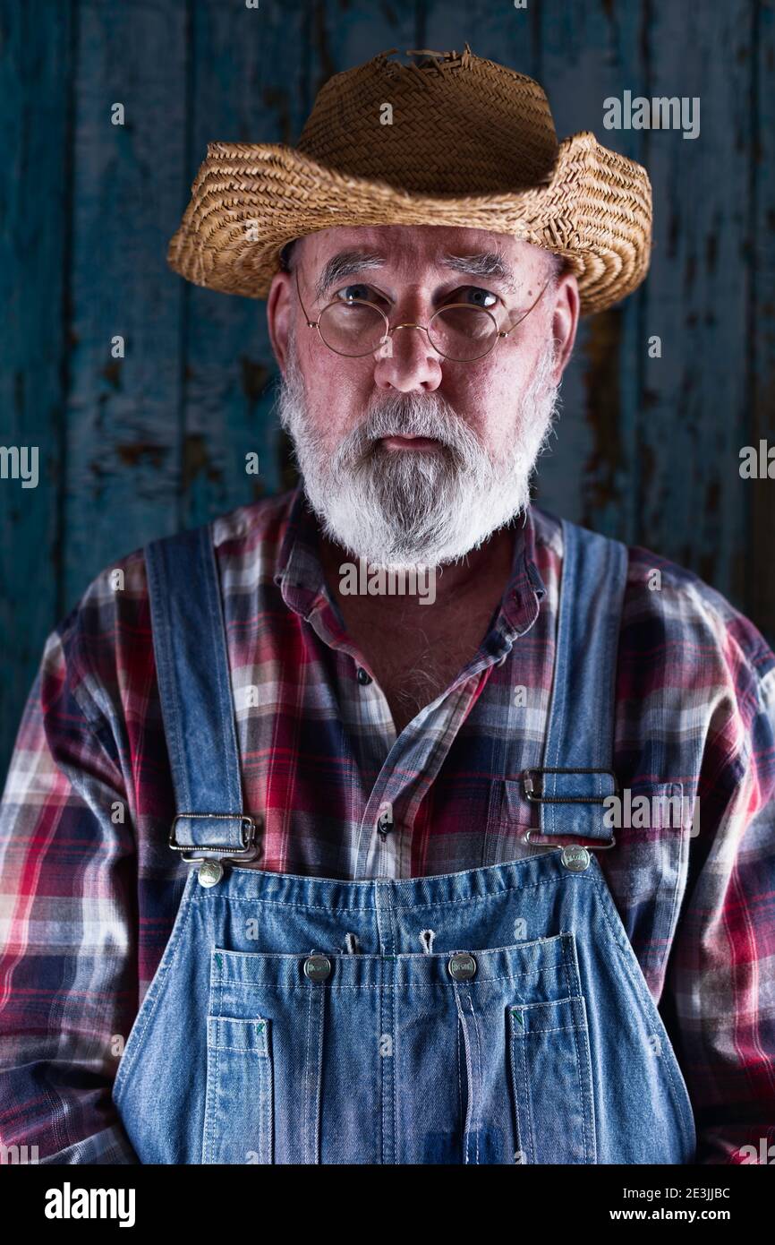 Portrait of an elderly man in bib overalls Stock Photo - Alamy