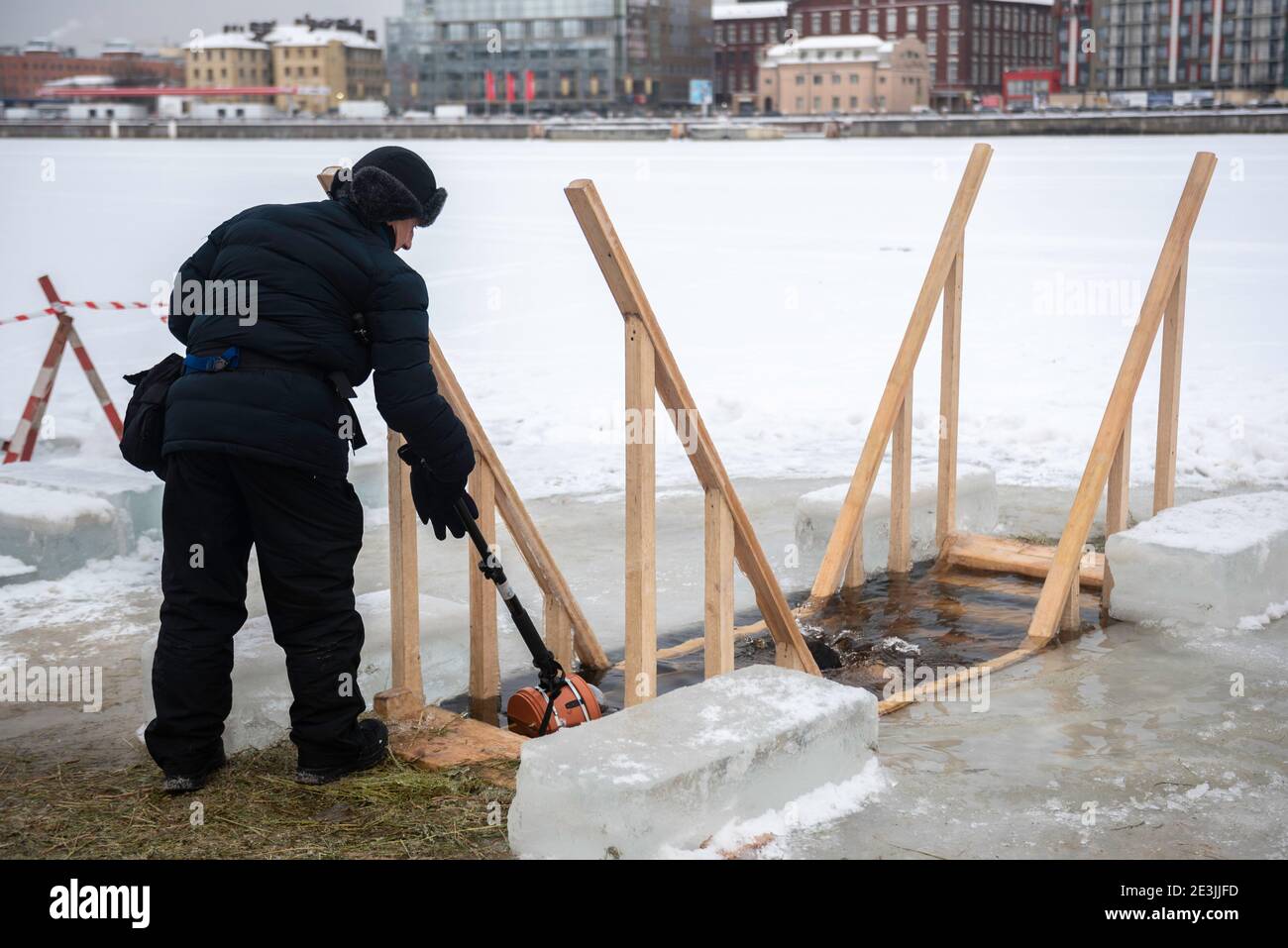 Man bathes into cold water of ice-hole on Epiphany day in Neva River ...