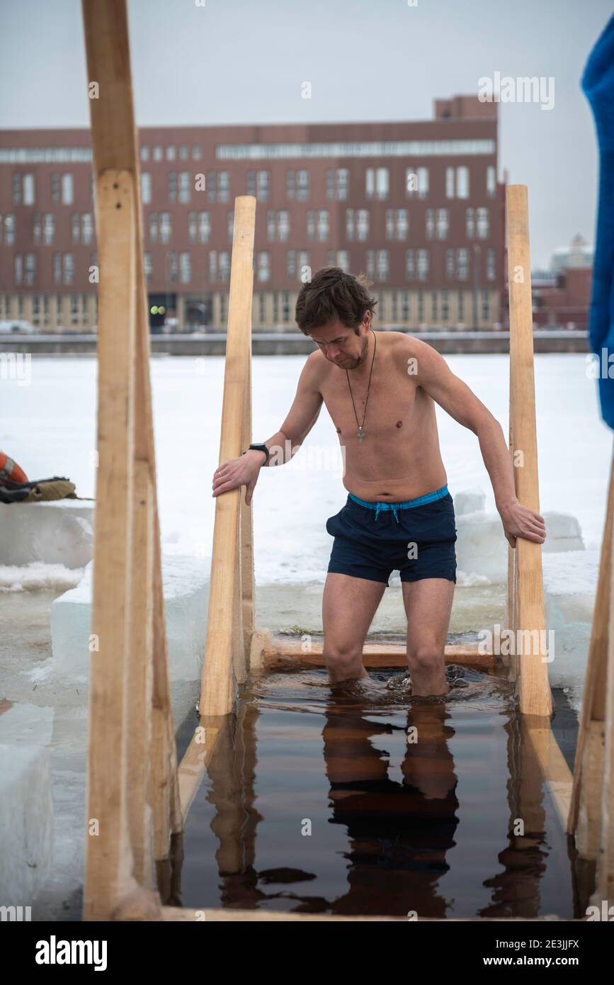 Man bathes into cold water of ice-hole on Epiphany day in Neva River ...