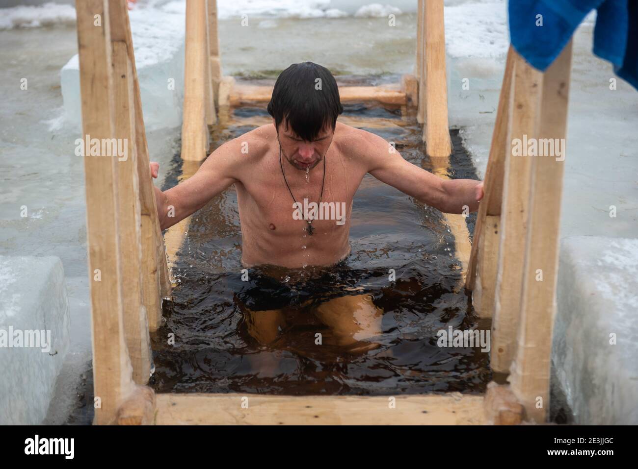 Man bathes into cold water of ice-hole on Epiphany day in Neva River ...