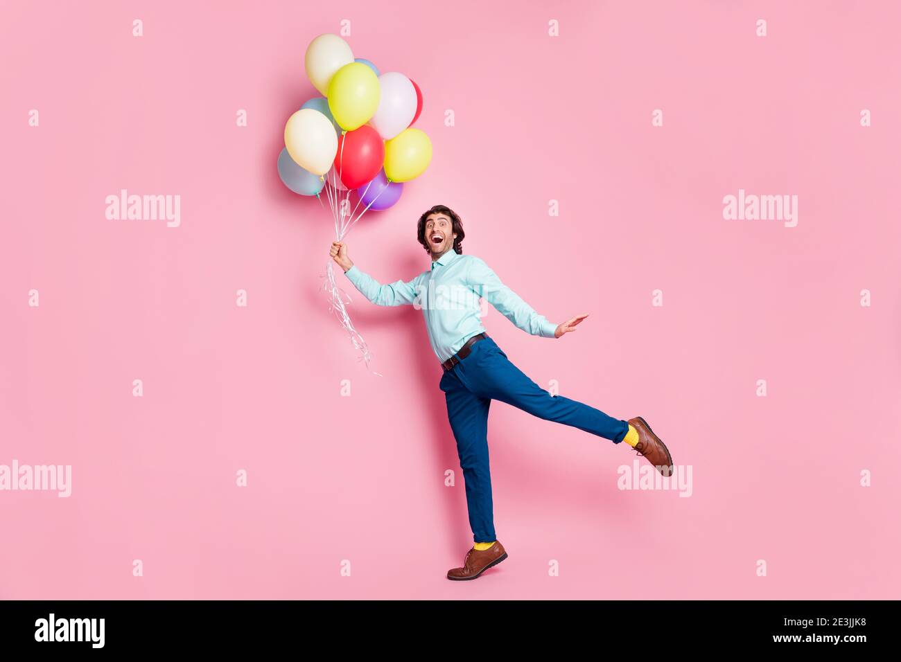 Photo portrait full body view of guy standing on one leg holding ...